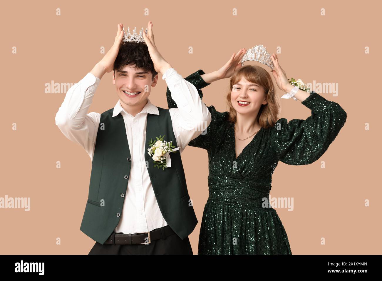Happy prom couple with crowns on beige background Stock Photo - Alamy