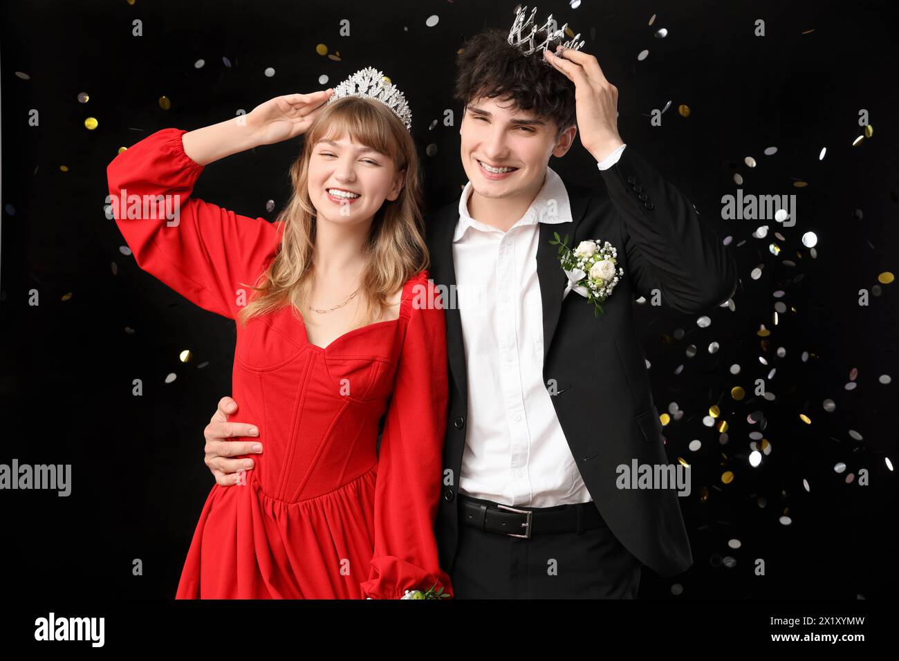 Happy prom couple with crowns and confetti on black background Stock ...