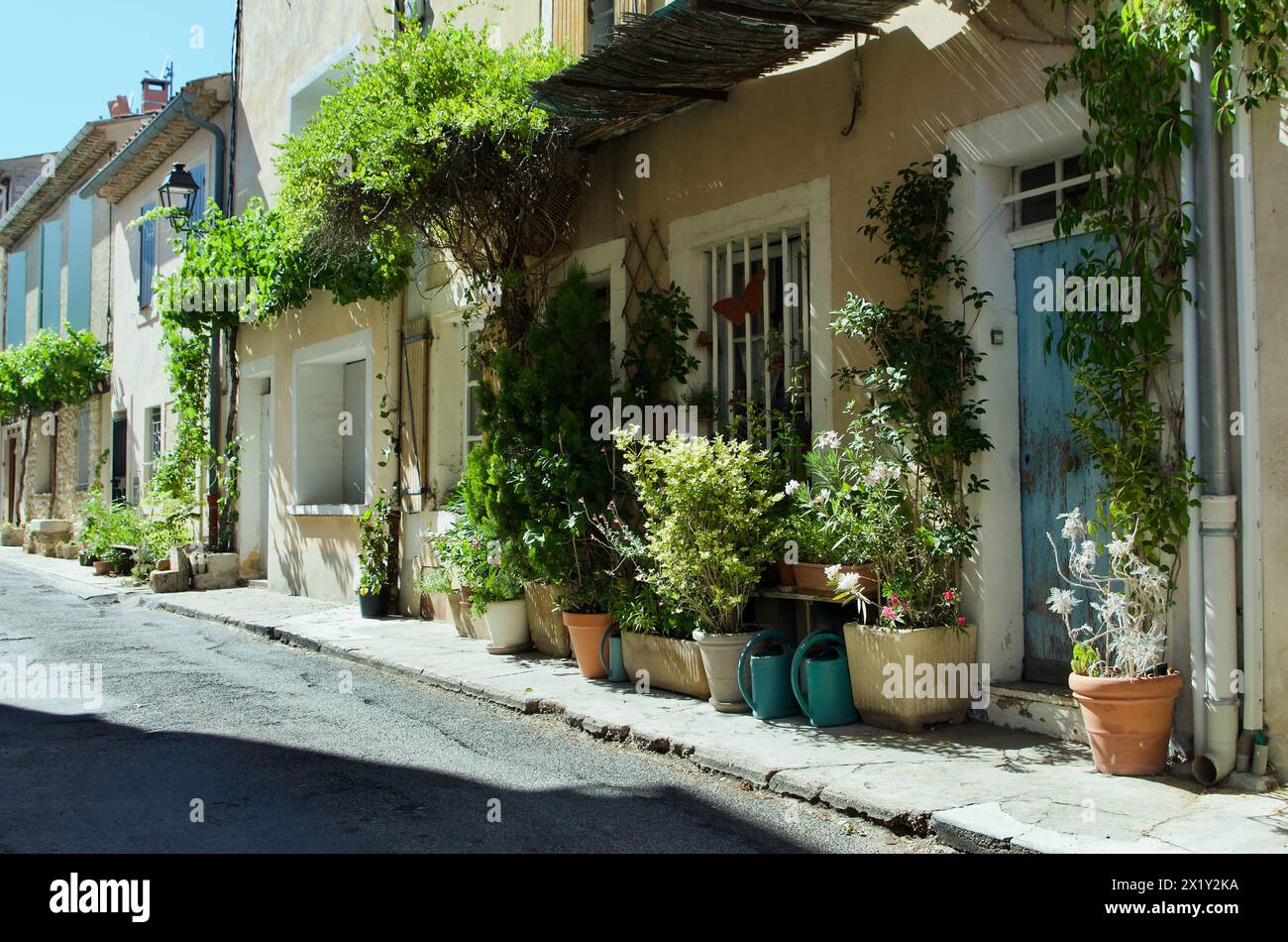 Street in a small French village with stone buildings and potted plants ...