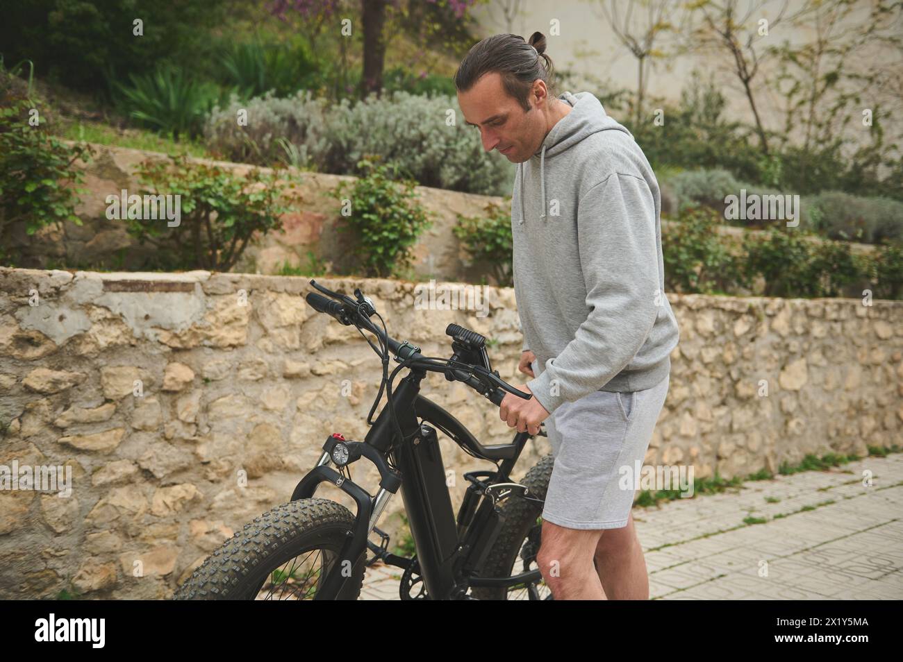 Caucasian muscular man pushing electric mountain bike. Healthy active ...