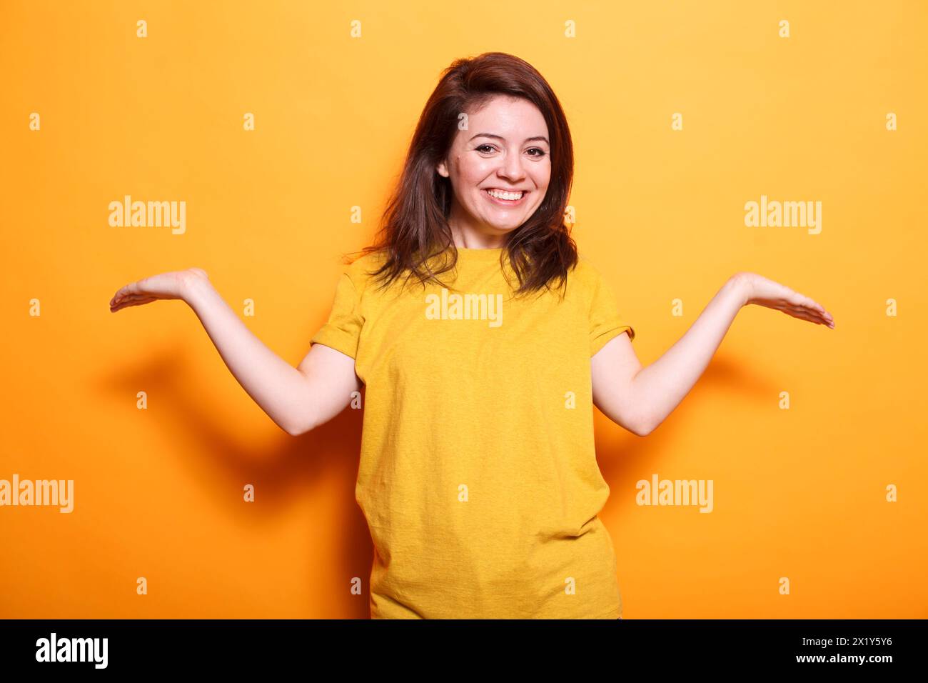 Delighted, thrilled woman with extended arms, brown hair, and a big ...