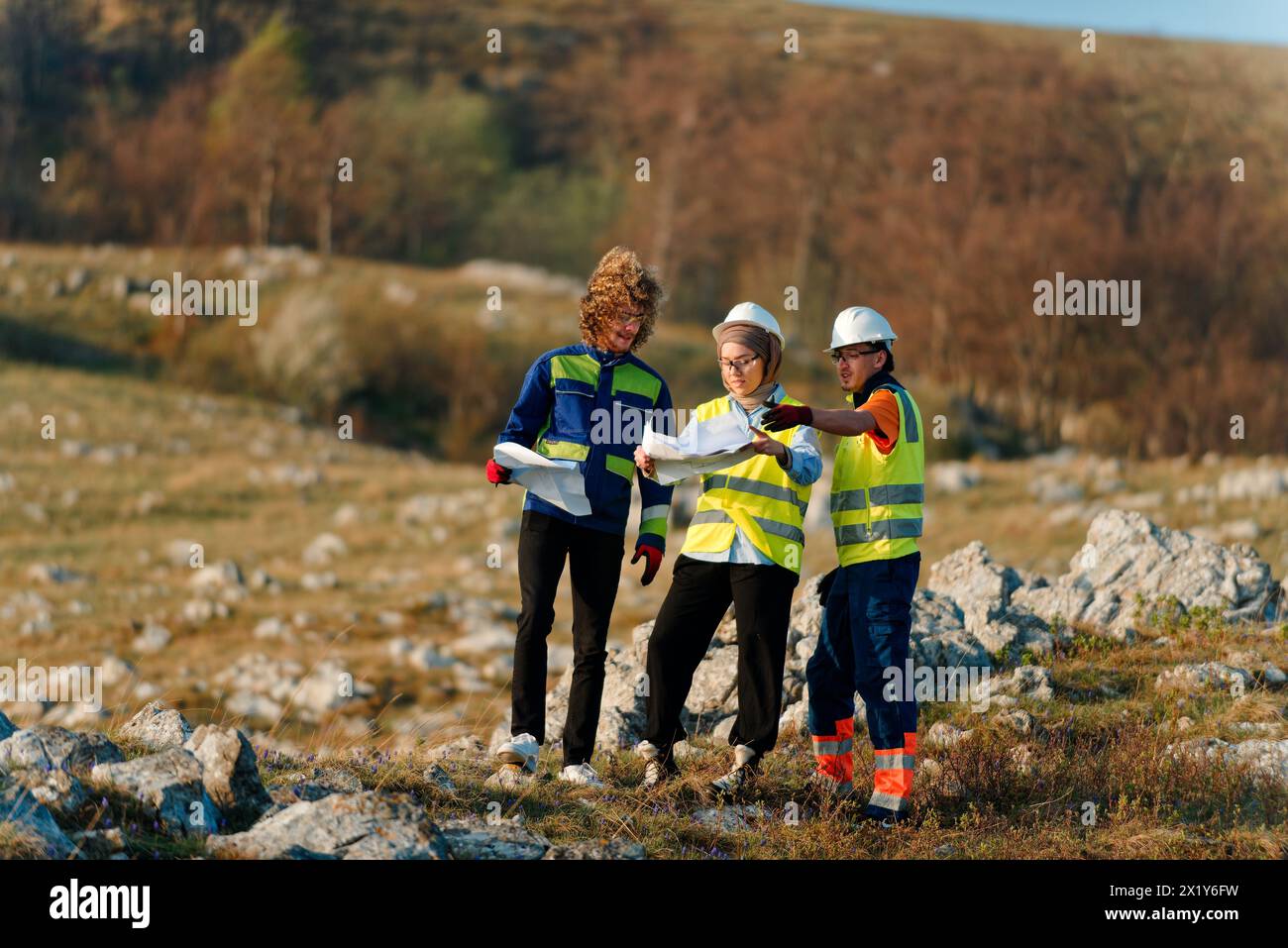 A team of engineers and workers oversees a wind turbine project at a ...