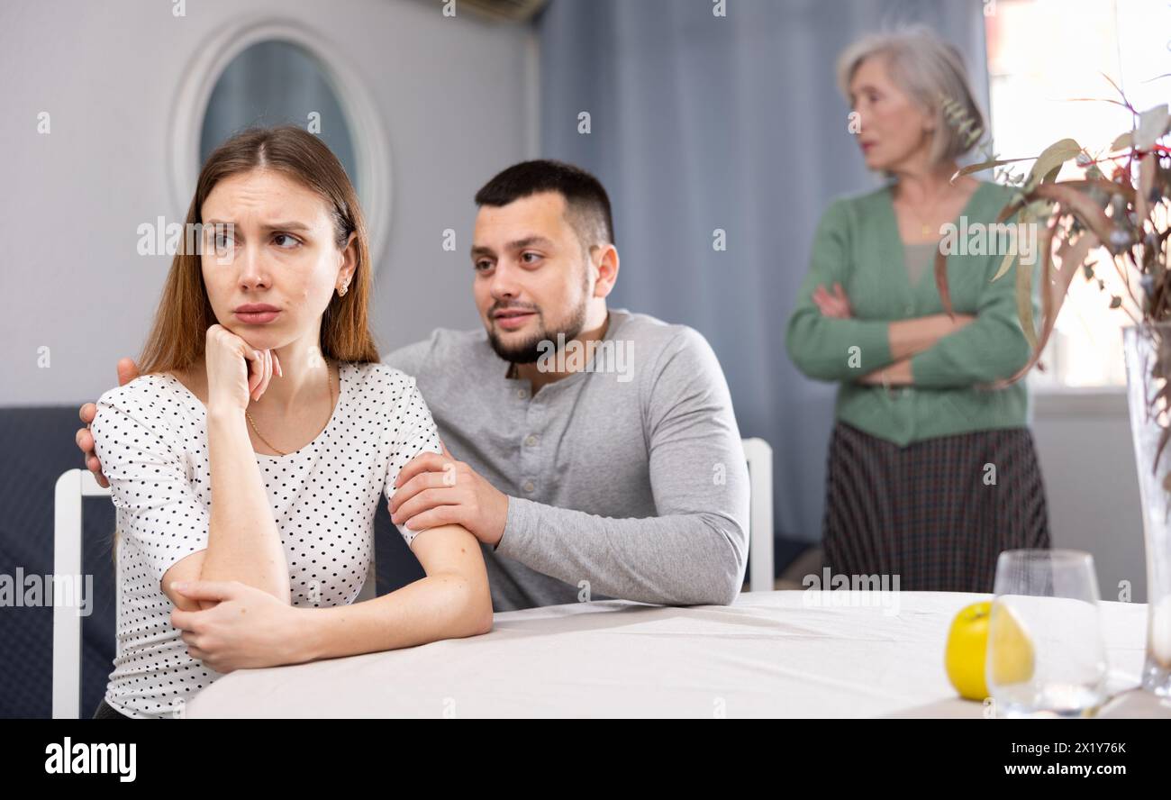 Domestic quarrel - husband and mother try to calm crying wife Stock ...