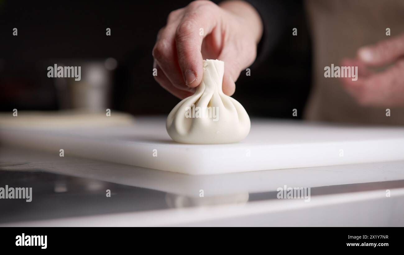 Woman chef makes dough for khinkali. Khinkali close-up. Cooking ...
