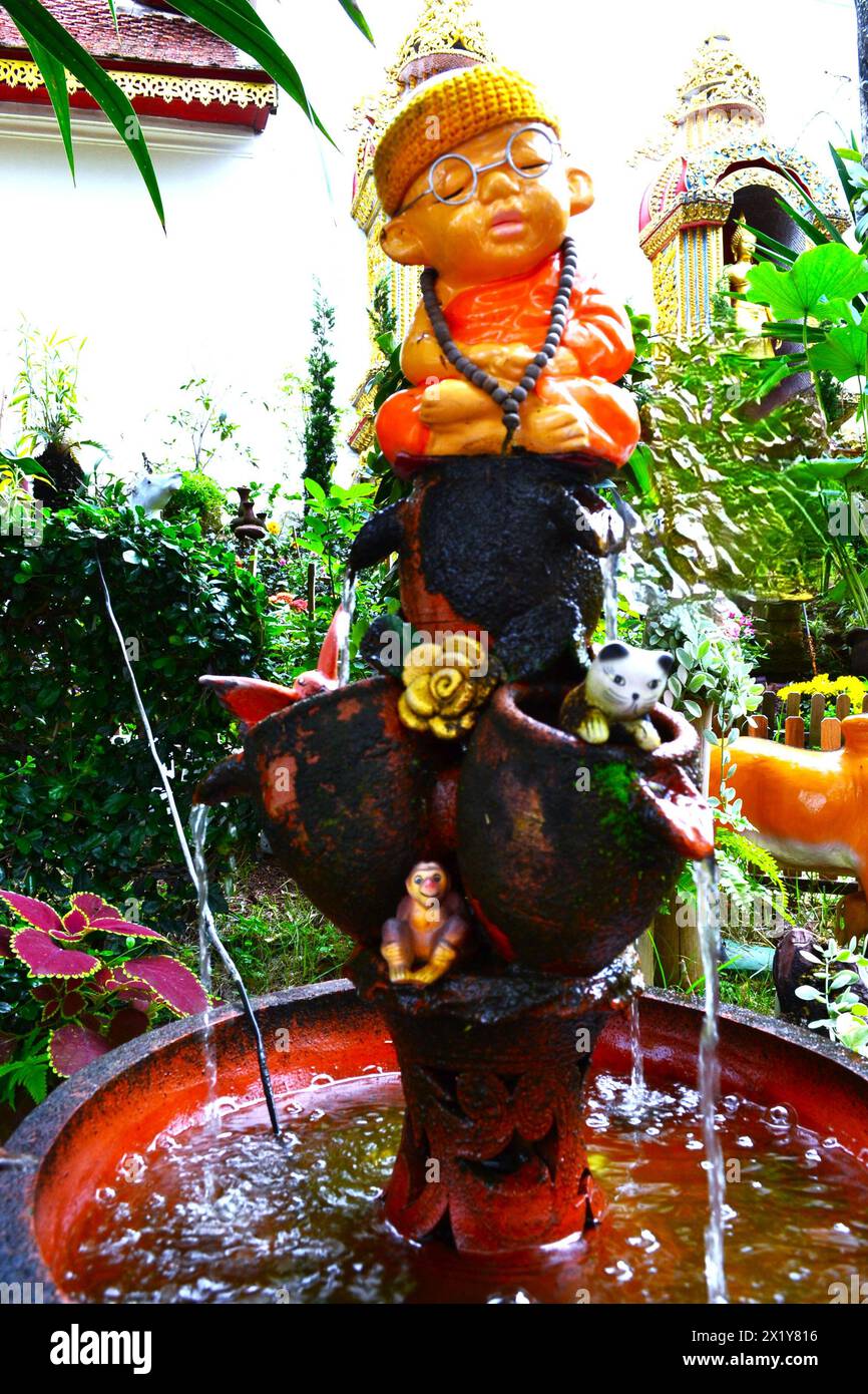 Small status of a sitting Monk in the backyard of a temple in ChiangMai ...