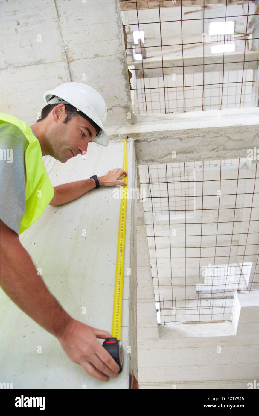 Worker with protective equipment, PPE, Taking measures in concrete beam ...