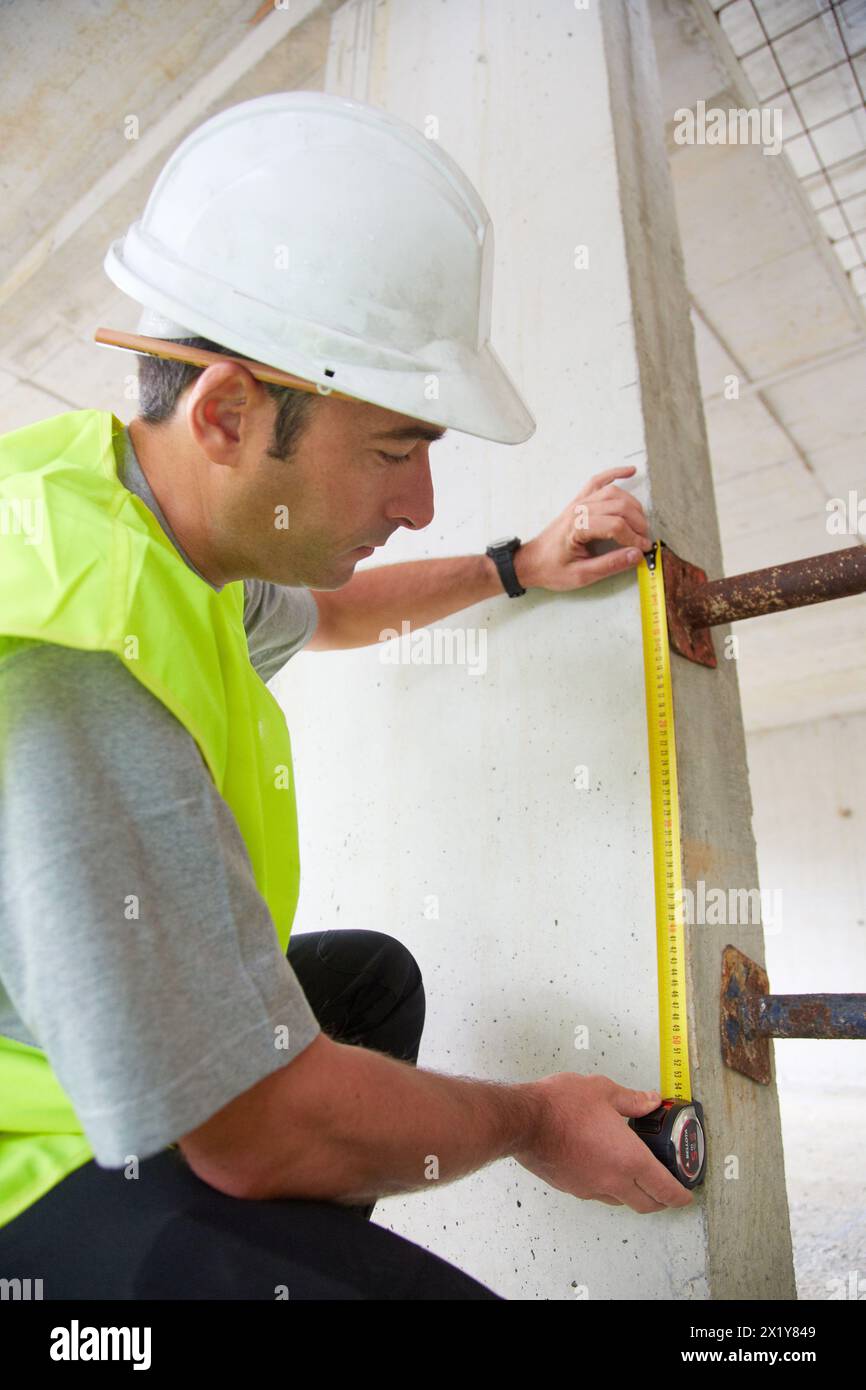 Worker with protective equipment, PPE, Taking measures in concrete beam ...