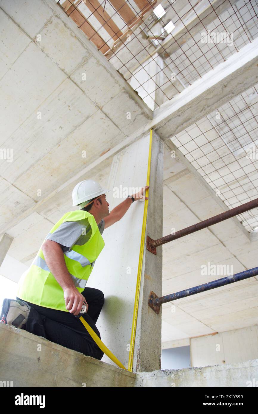 Worker with protective equipment, PPE, Taking measures in concrete beam ...