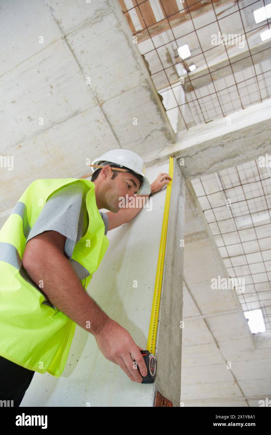 Worker with protective equipment, PPE, Taking measures in concrete beam ...