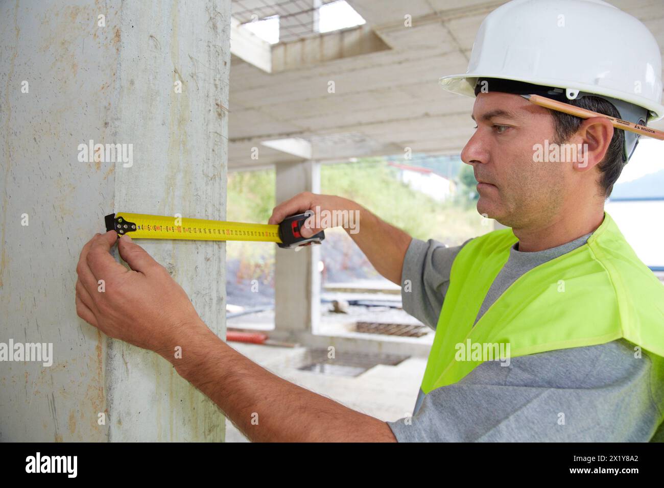 Worker with protective equipment, PPE, Taking measures in concrete beam ...