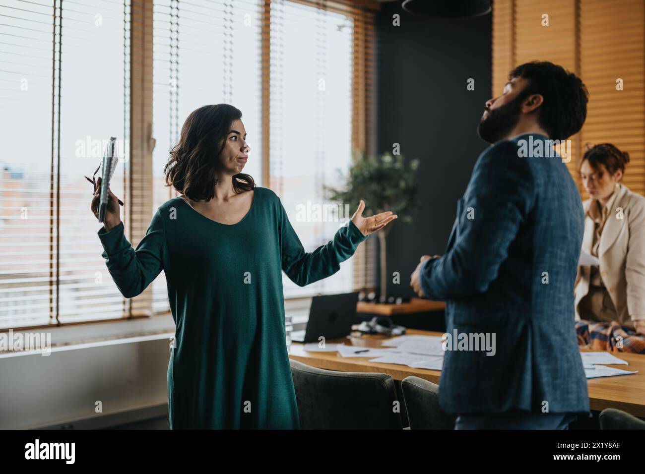 Creative team engaging in lively discussion during office meeting Stock ...