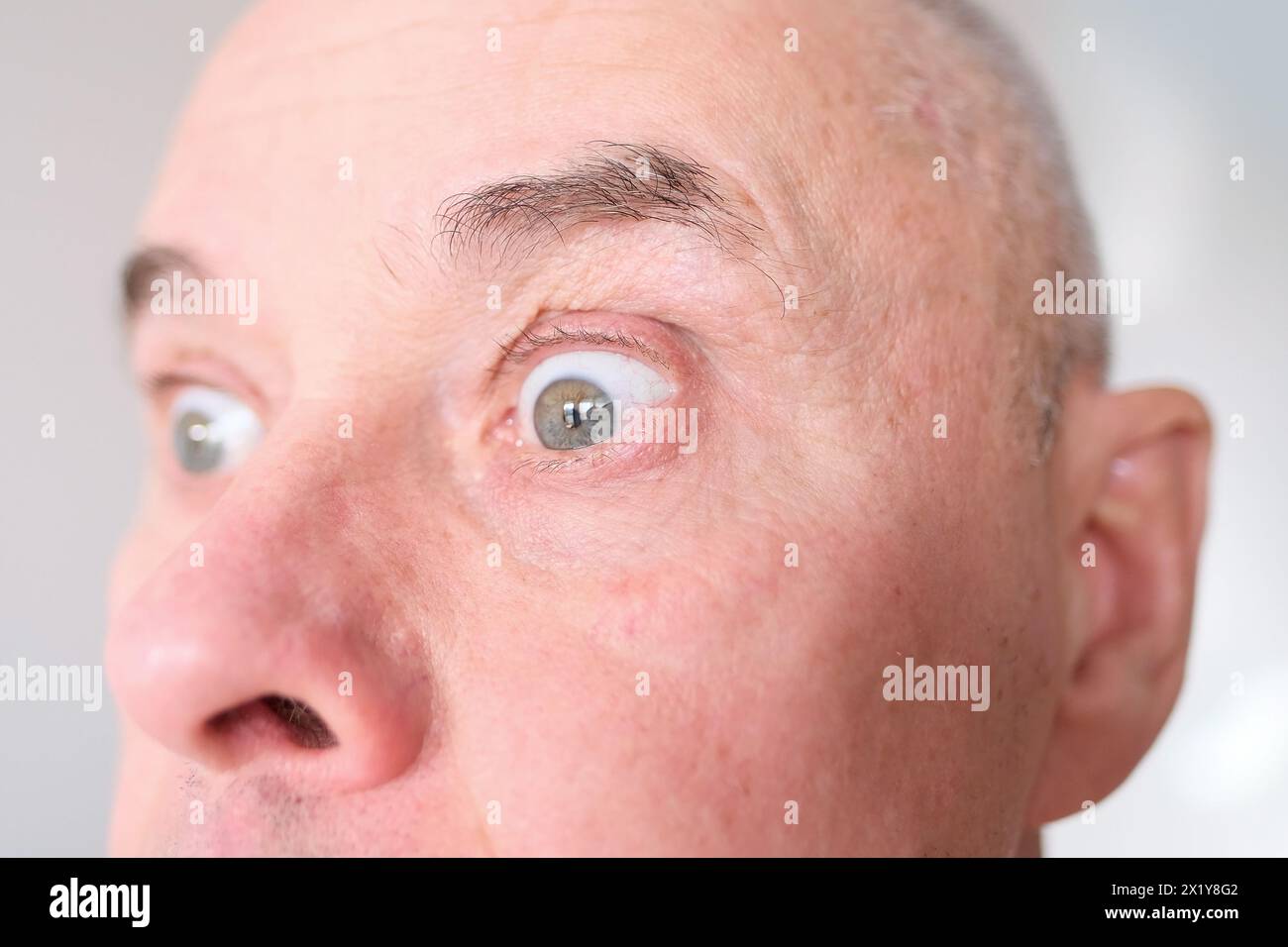close-up and front view of the gray eye of an old caucasian man in his ...