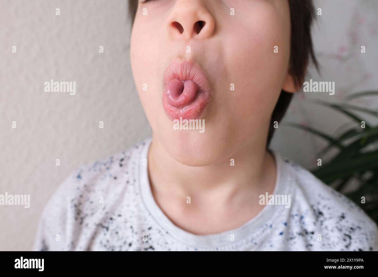 small child, kid performs articulation exercises for mouth, rolls the ...