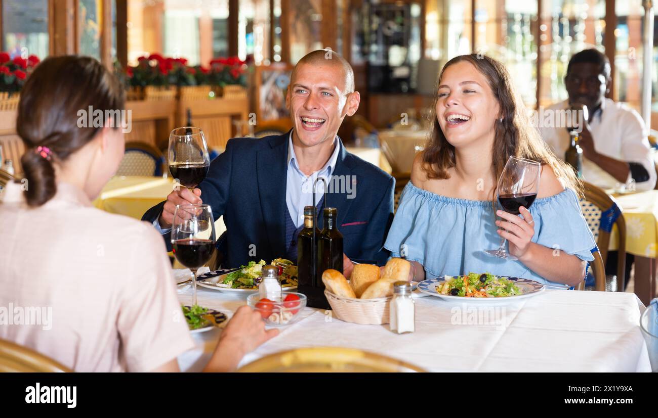 Two cheerful couples having dinner and nice talking Stock Photo - Alamy