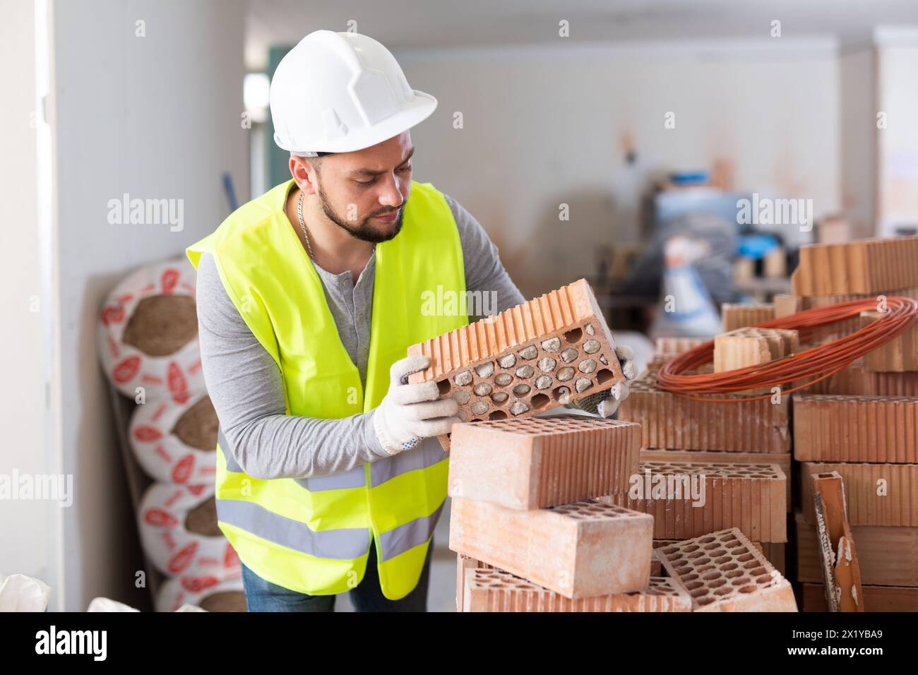 Construction worker checking bricks at renovating object Stock Photo ...