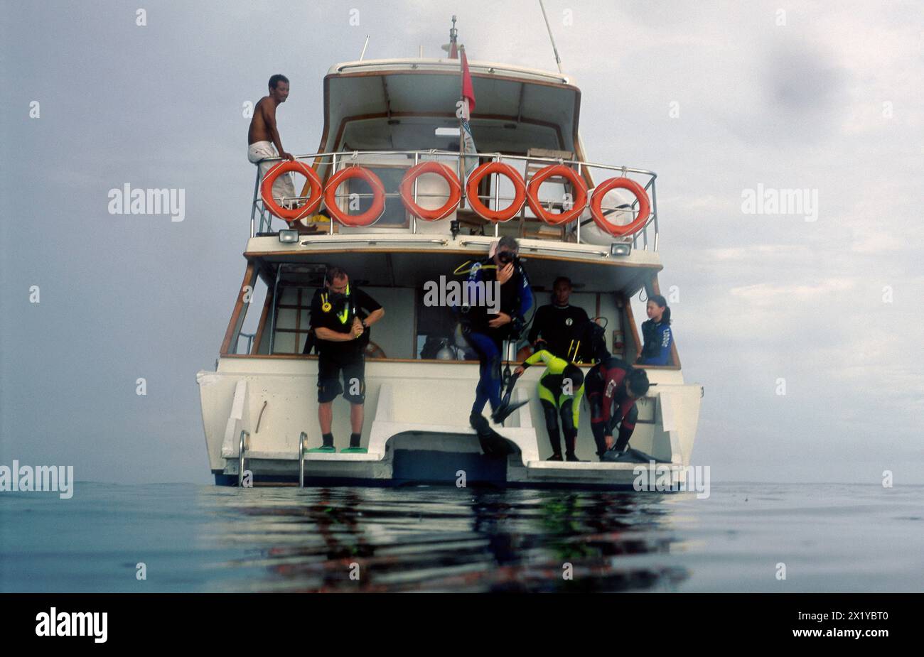Diver entering water from boat by giant stride, Kura-kura Resort ...