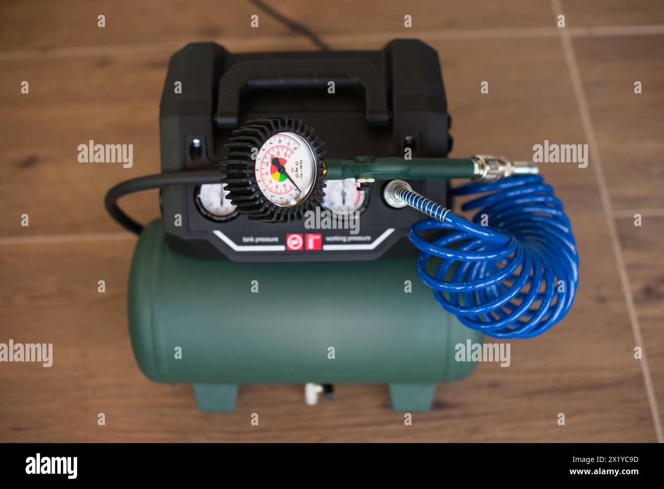 Green air compressor with pressure gauge connected to a compressor via ...