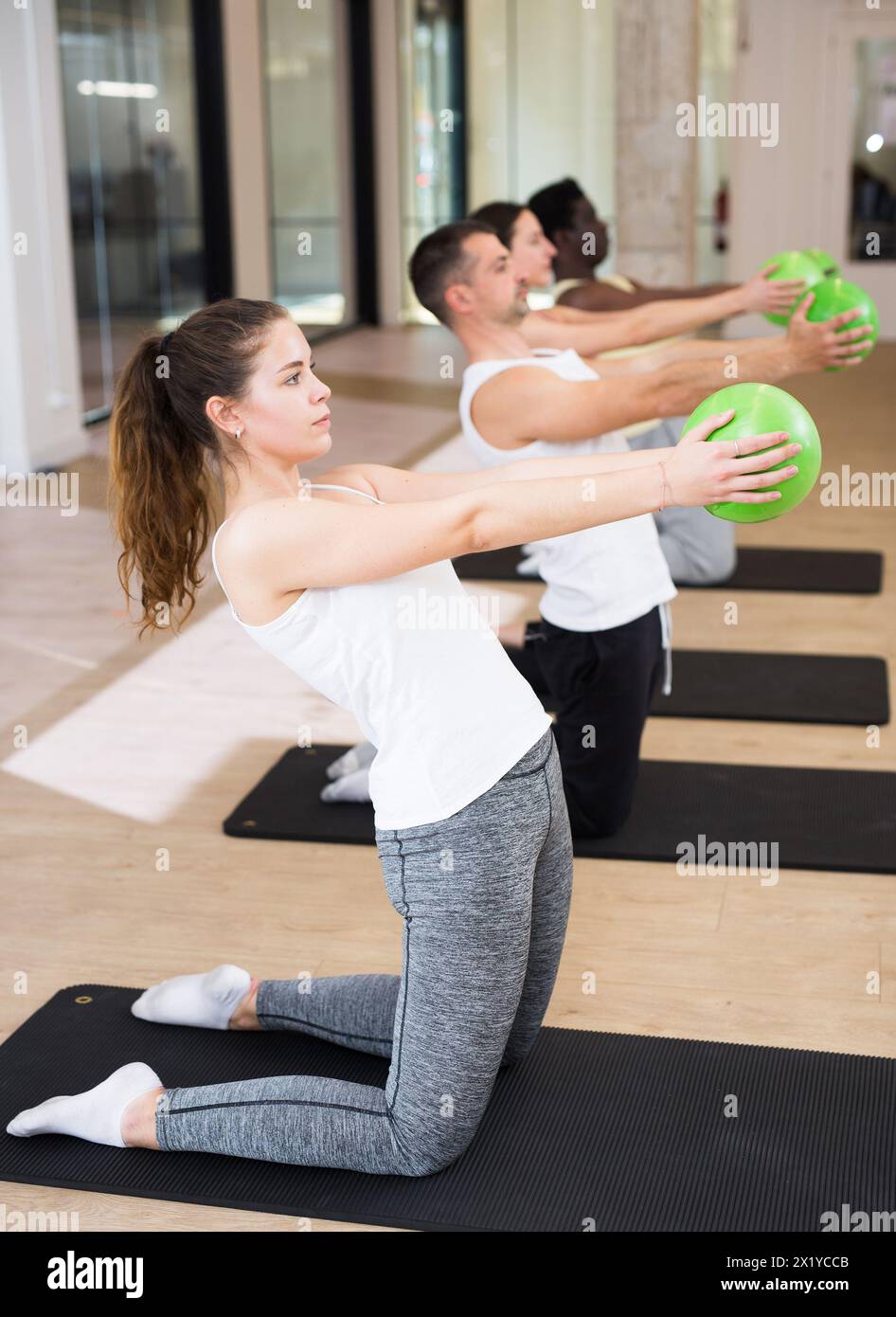 Sporty girl exercising with bender ball during group training Stock ...
