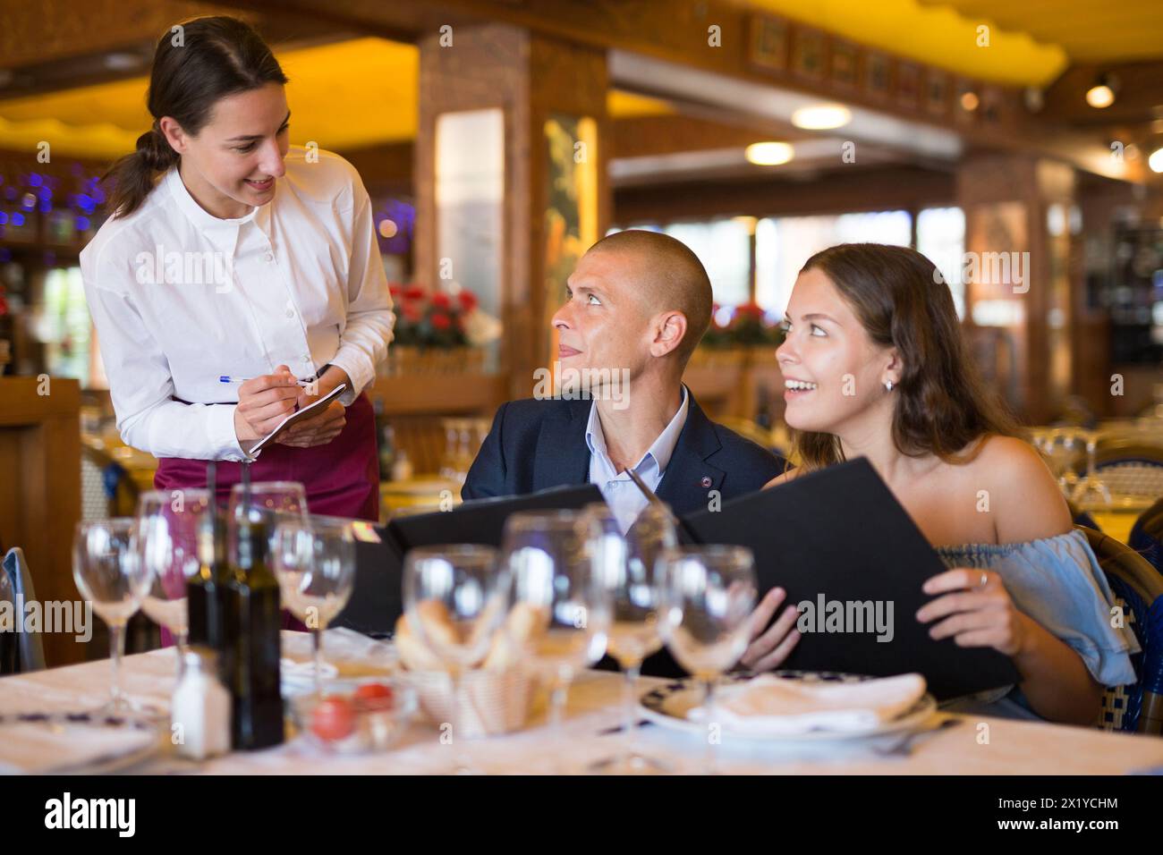 Woman waiter is taking order from clients in restaurante Stock Photo ...