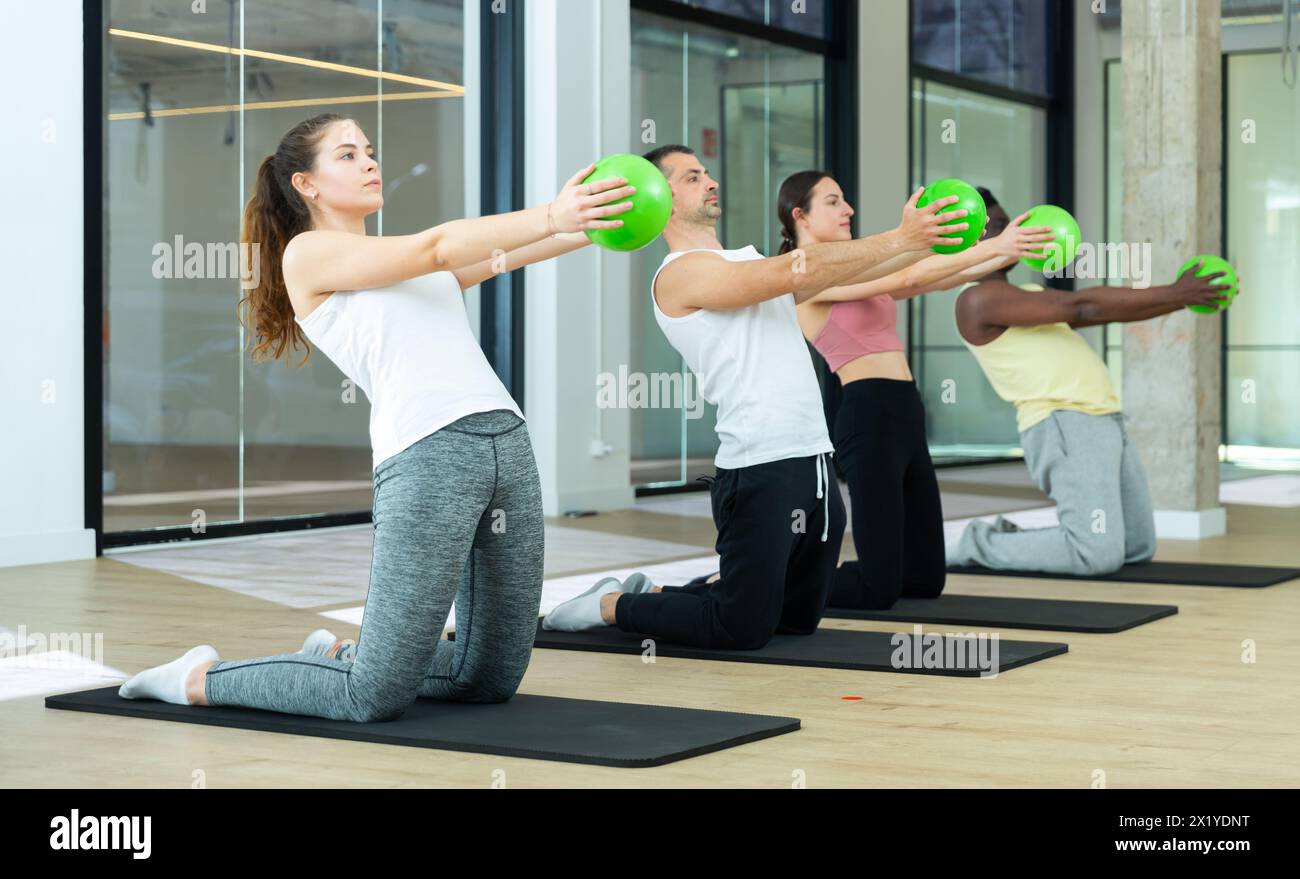 Sporty young adults doing pilates exercises with bender balls Stock ...