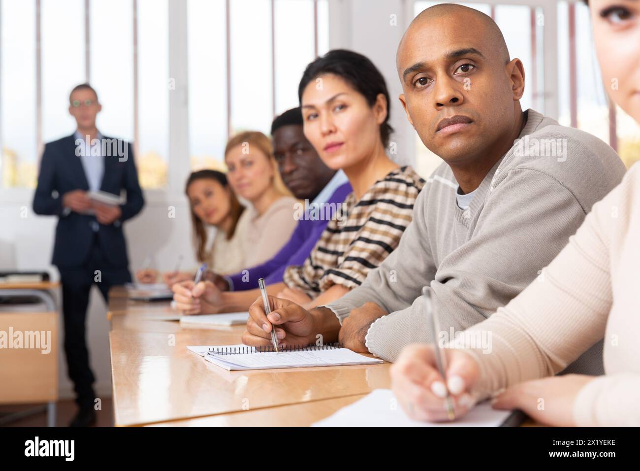 Side view of student group working on lecture in classroom, making ...