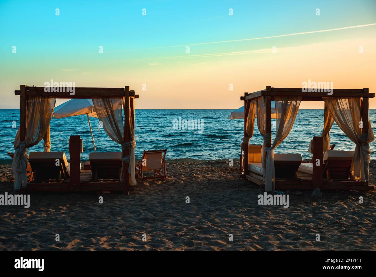 Beach cabana beds and sun loungers on the seashore at sunset Stock ...