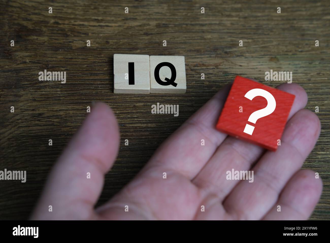 word IQ, question mark in female hand on rustic wooden background ...