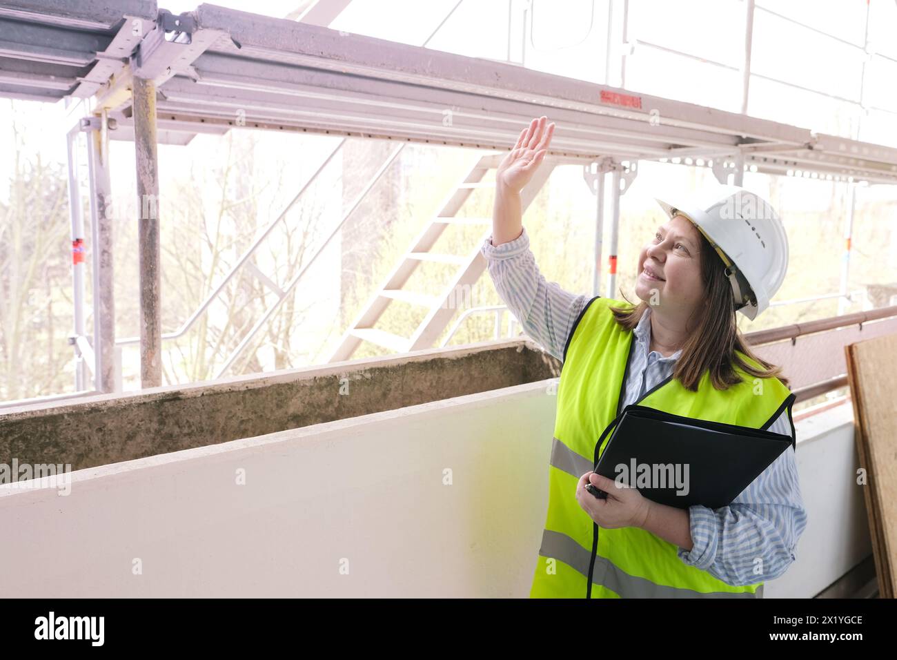 experienced woman architect, constructor engineer in protective white ...