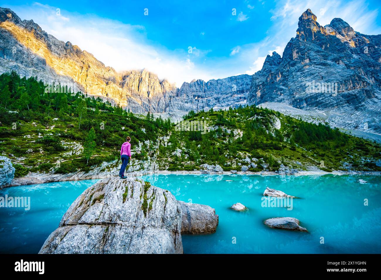 Description: Athletic woman enjoys beautiful view from huge boulder on ...