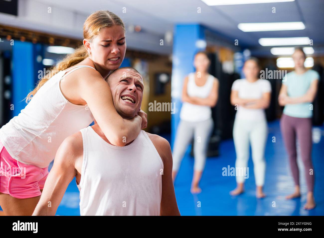 Girl performing rear choke hold while sparring with male opponent Stock Photo - Alamy