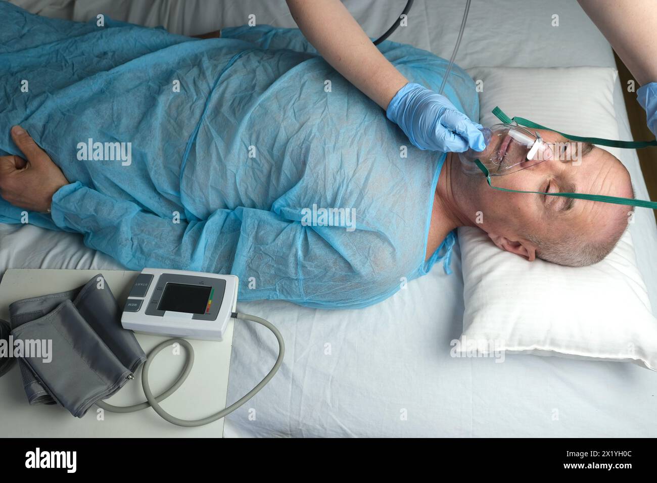 elderly man patient in blue shirt lies, the doctor puts on facial ...