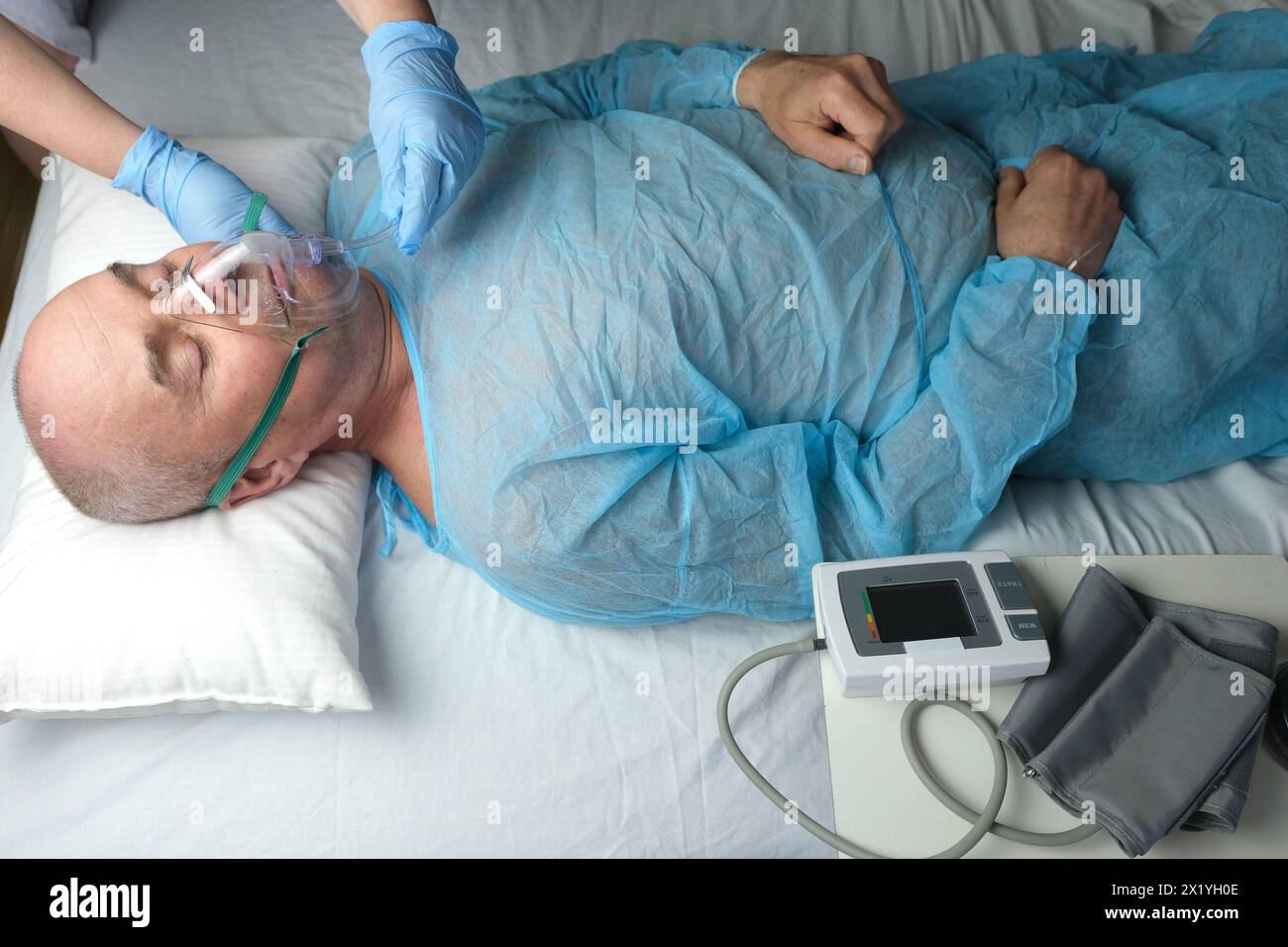 elderly man patient in blue shirt lies, the doctor puts on facial ...