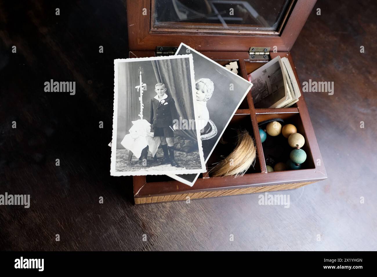 closeup old wooden box, a stack of retro photos, a lock of hair ...