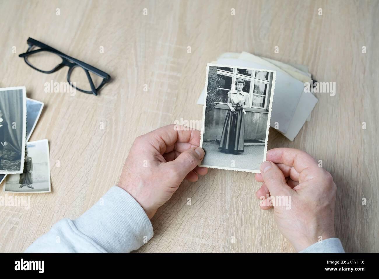 closeup male hand holding old vintage photos of 1940-1950, glasses on ...