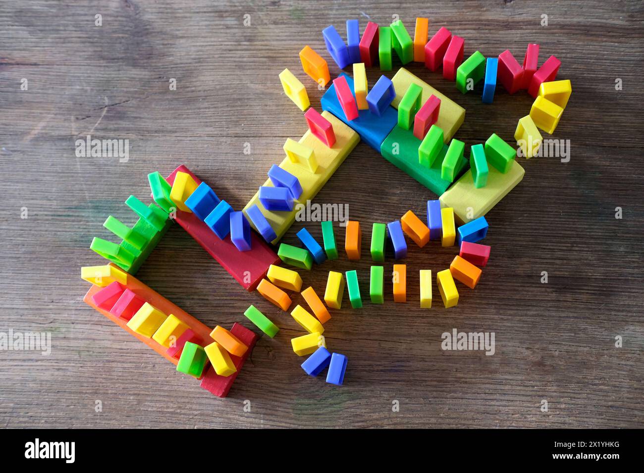 close-up of lines of dominoes, colored cubes of dominoes fall one after ...