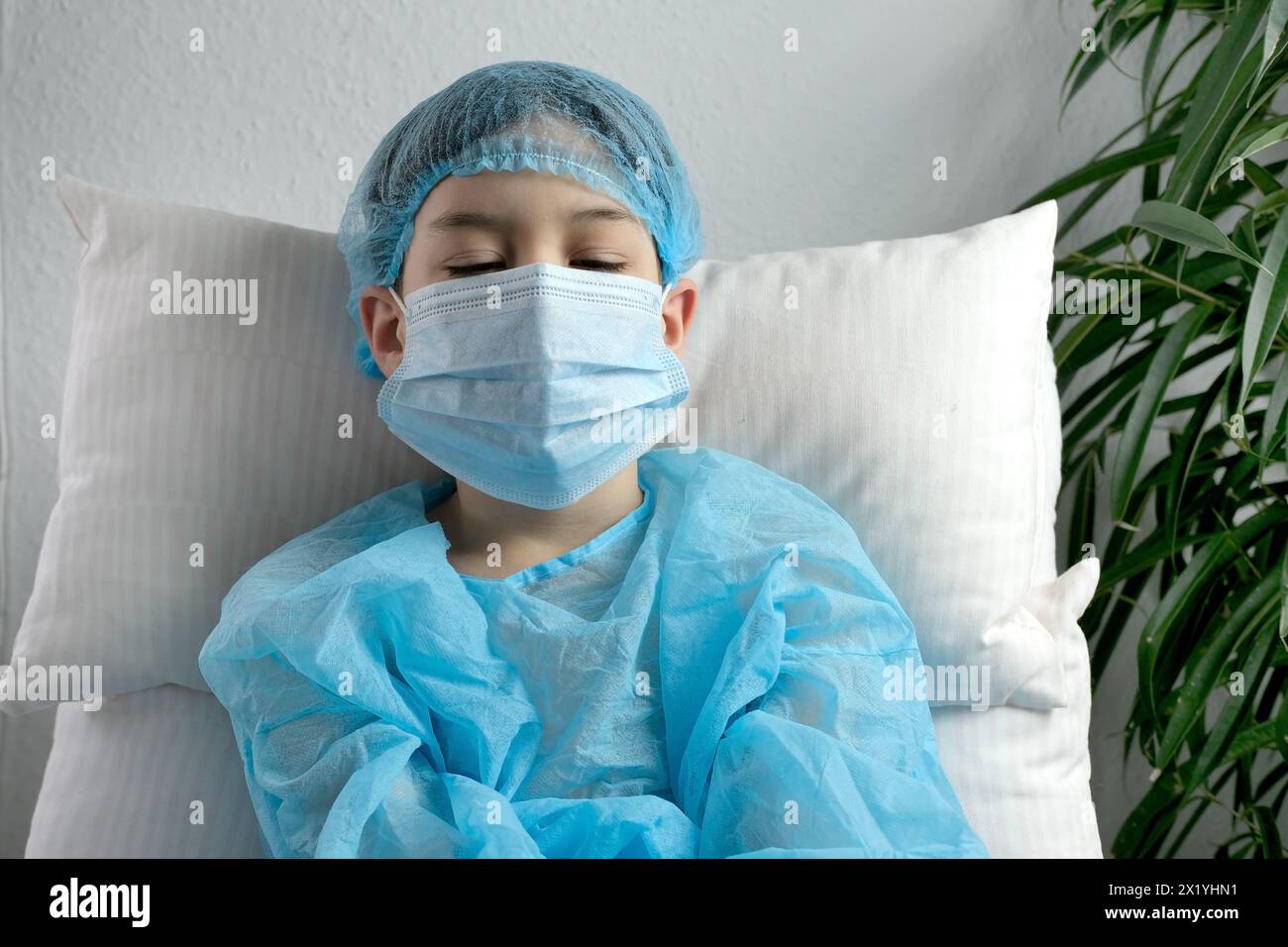 little patient in blue shirt, child, boy lies, white medical mask ...