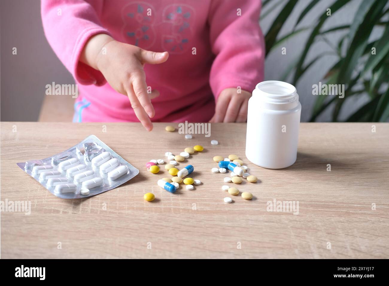 female hand of a small child, baby, girl playing with medical pills ...