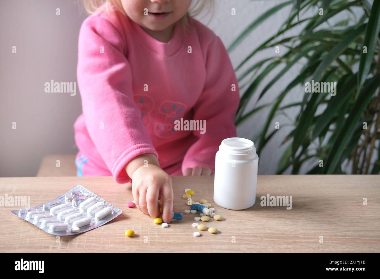 female hand of a small child, baby, girl playing with medical pills ...