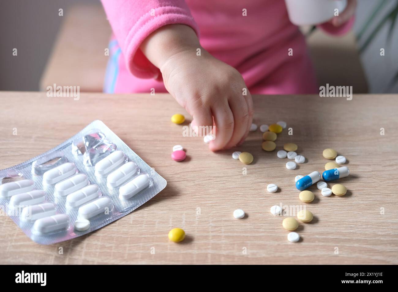 female hand of a small child, baby, girl playing with medical pills ...