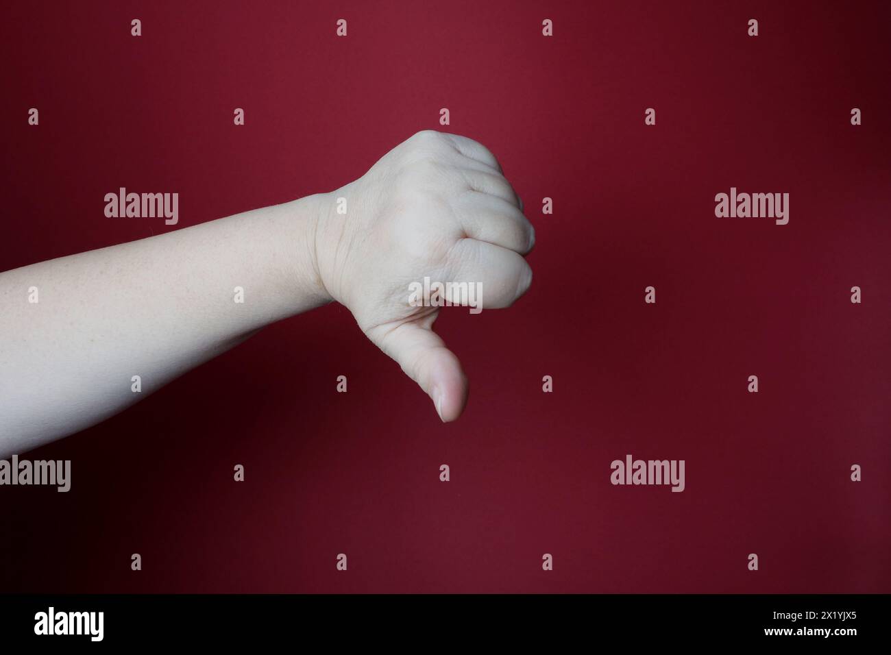 closeup female hand holding thumb down, disapproval gesture, no sign ...