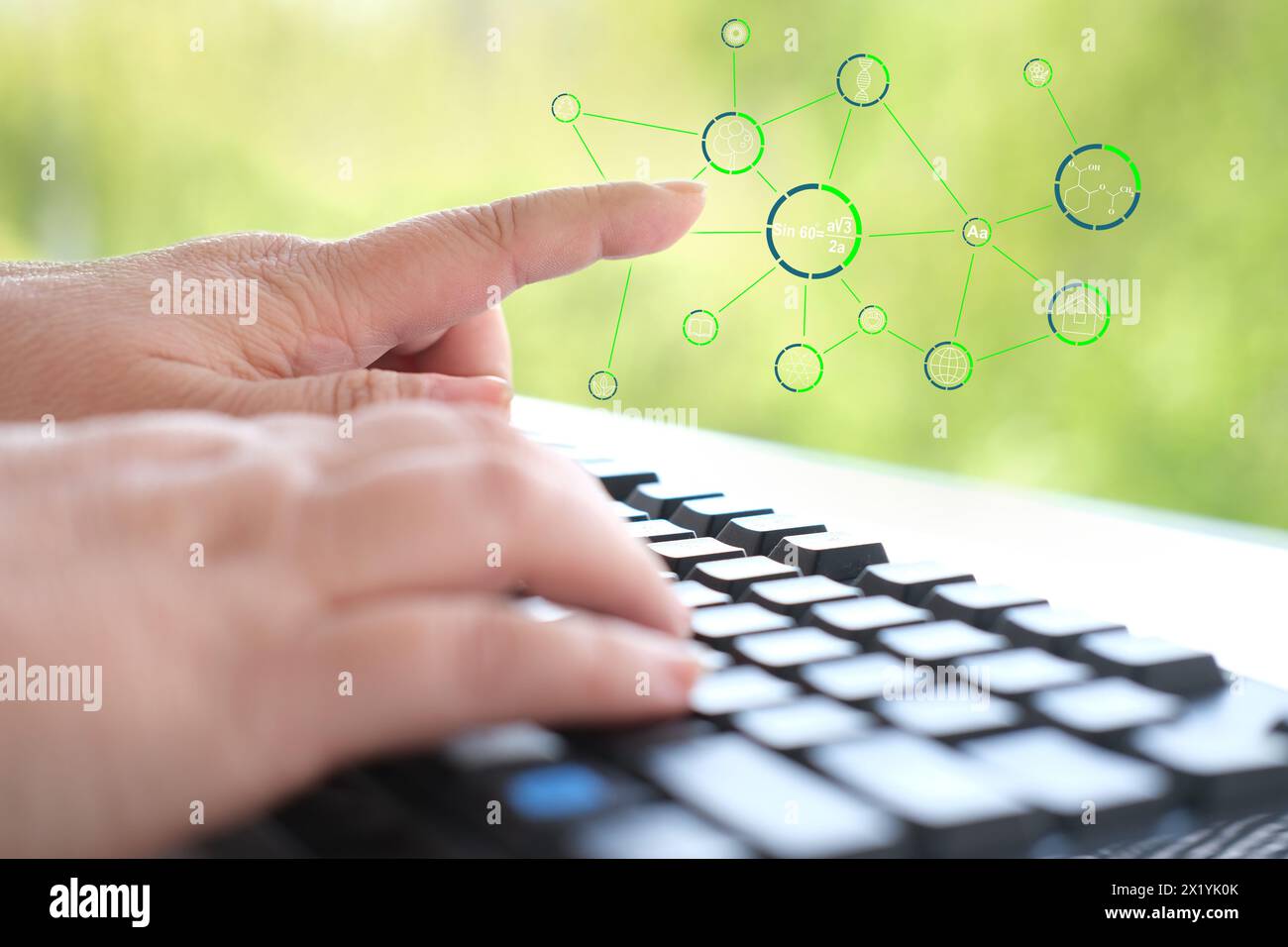 close-up female hand typing text on a computer keyboard on a natural background, workplace ...