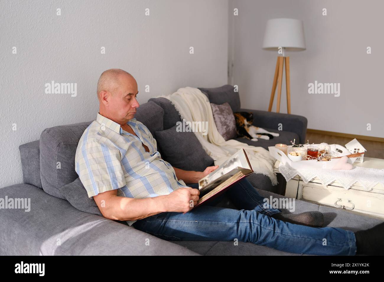 an elderly man looks through an album with old photographs, a concept ...