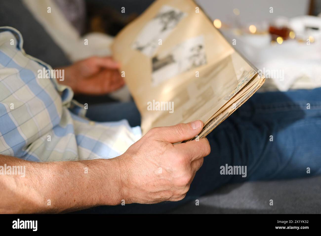 an elderly man looks through an album with old photographs, a concept ...
