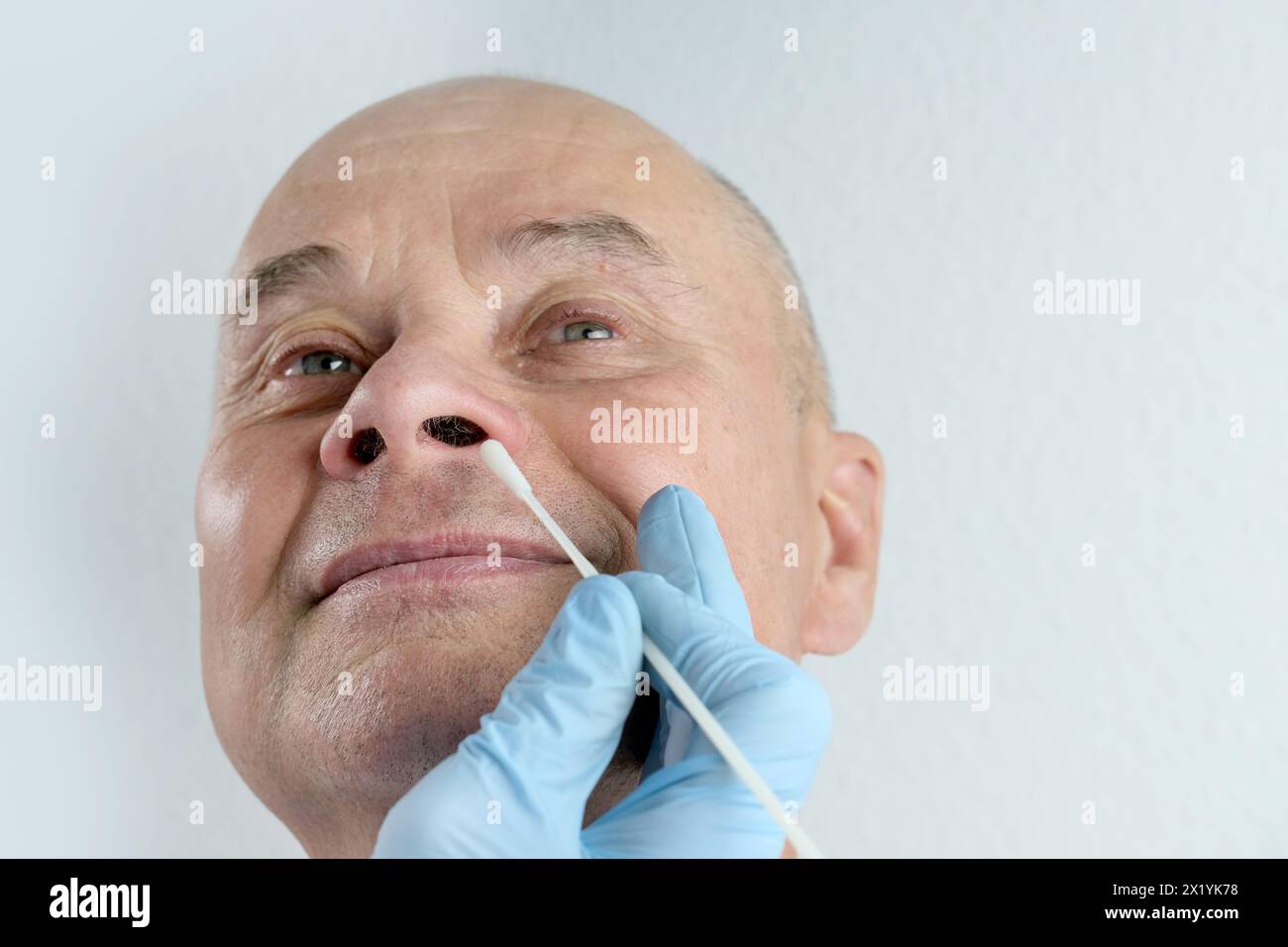 close-up of male doctor in gloves takes with swab sample from nose for ...