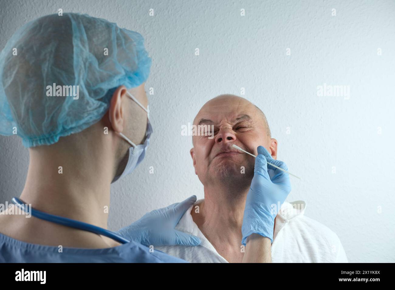 male doctor in gloves takes with swab sample from nose for analysis ...