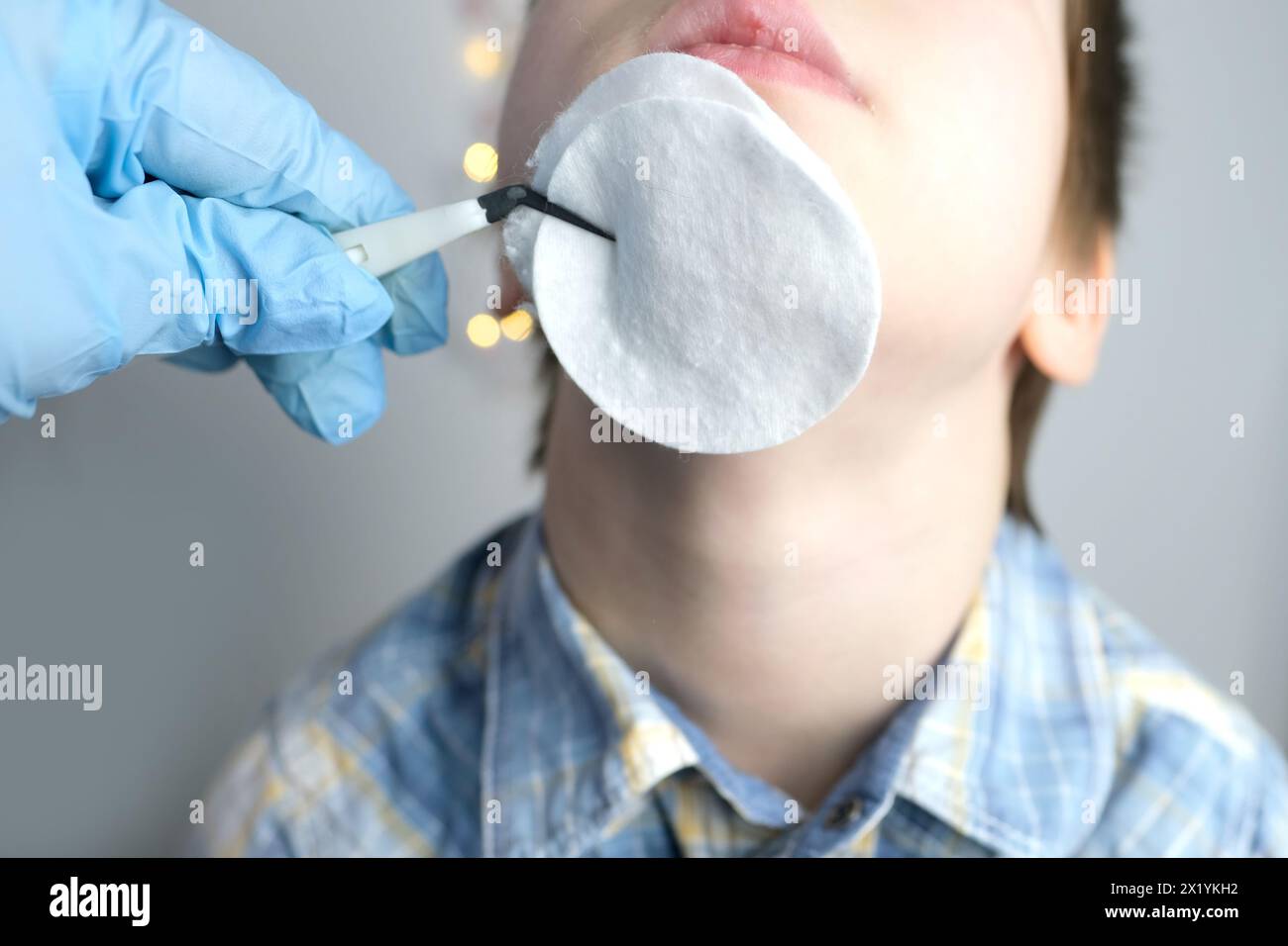 small child, kid 7-8 years old raised his head, assistant treats a ...