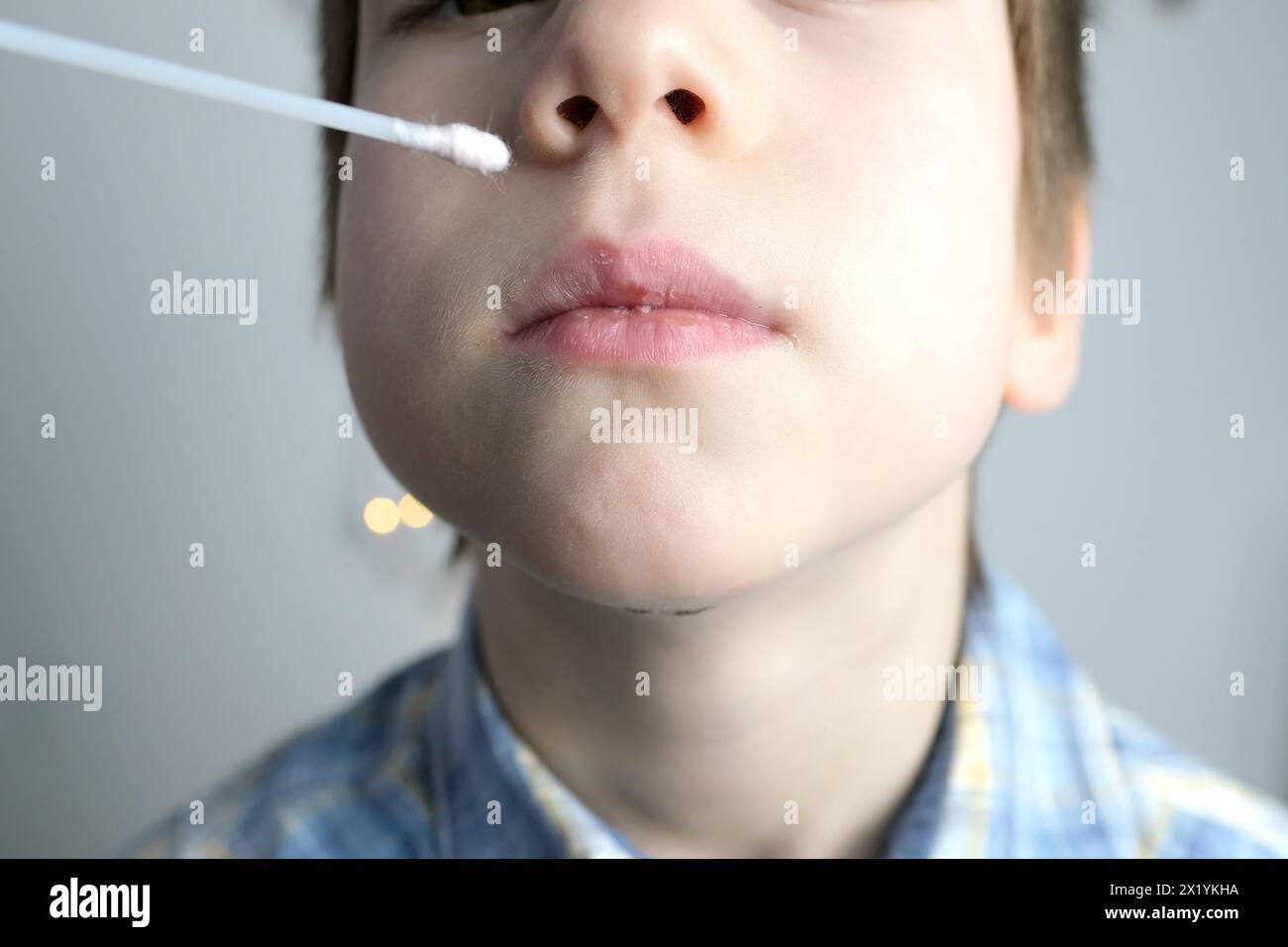 parent takes cotton bud from child’s nose to analyze saliva, mucous ...