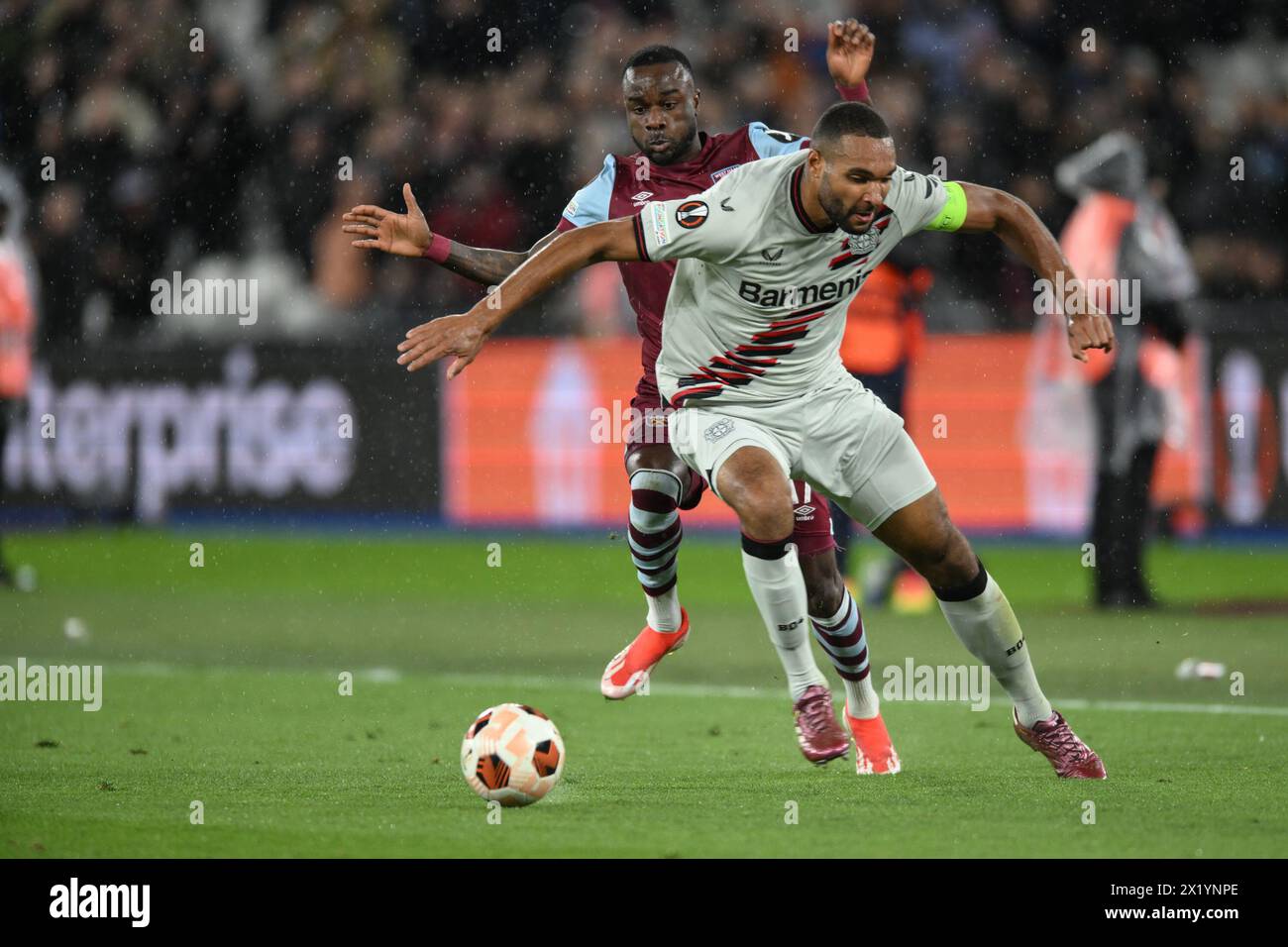 Maxwell Cornet of West Ham United challenges Johnathan Tah of Bayer 04 ...