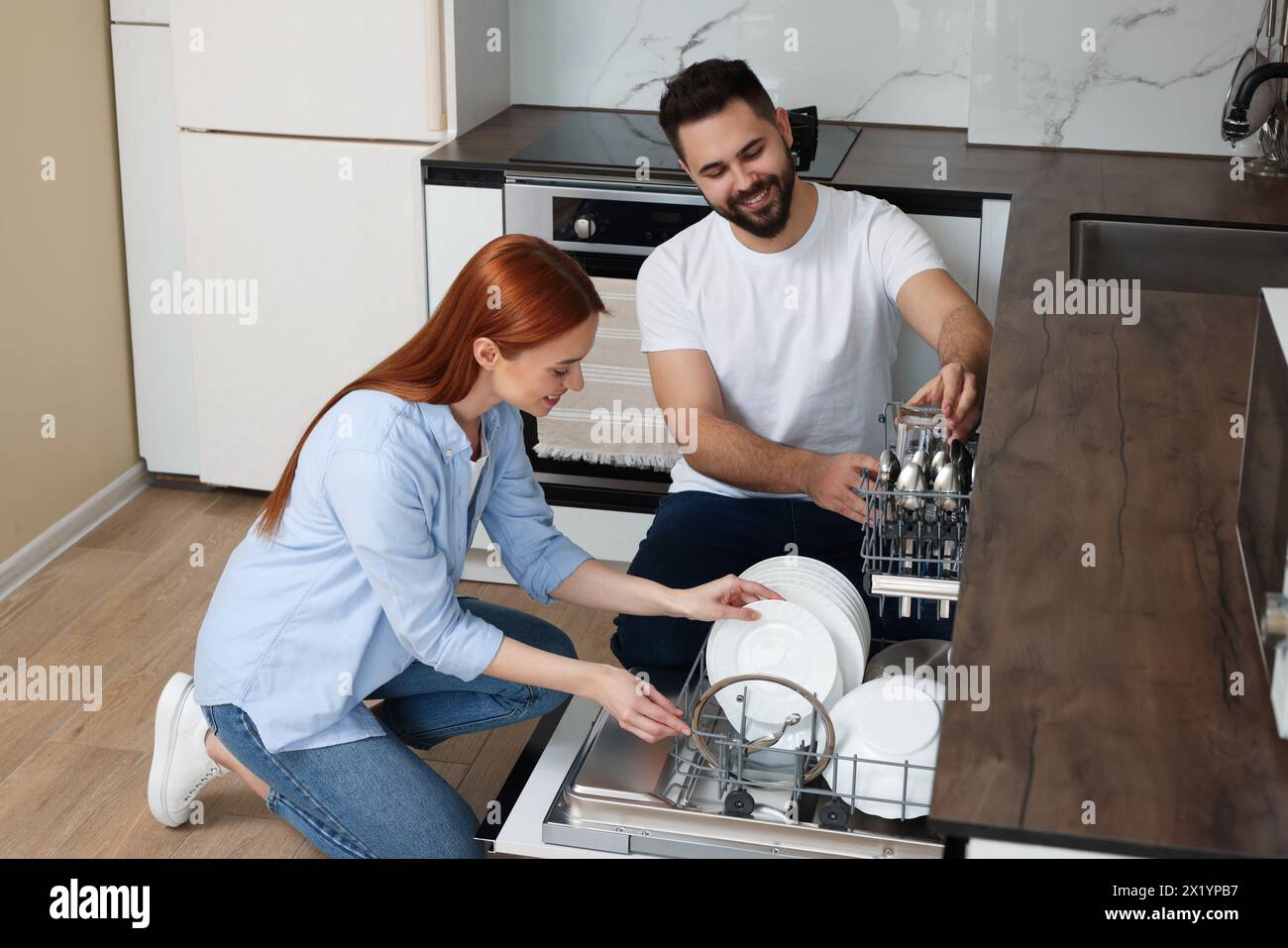 Man loading dishwasher woman hi-res stock photography and images - Alamy