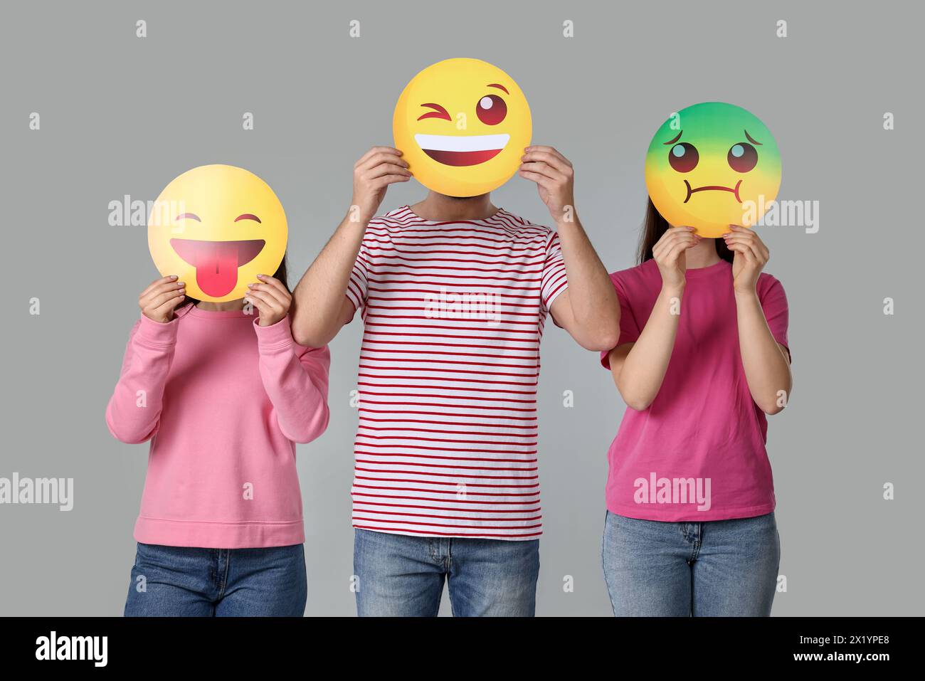 People covering faces with emoticons on grey background Stock Photo - Alamy